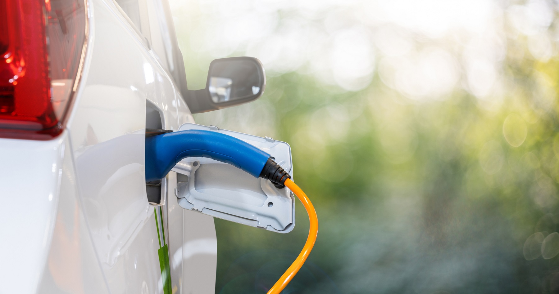Close up of electric car inlet with a connected charging cable on a ...